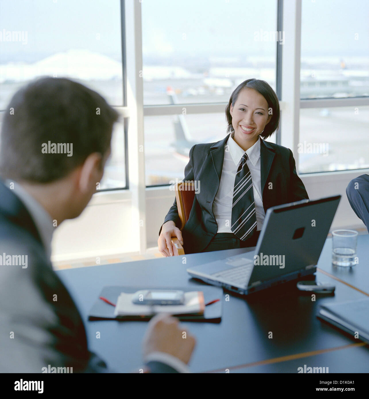 Smiling business people meeting at table in conference room with a ...
