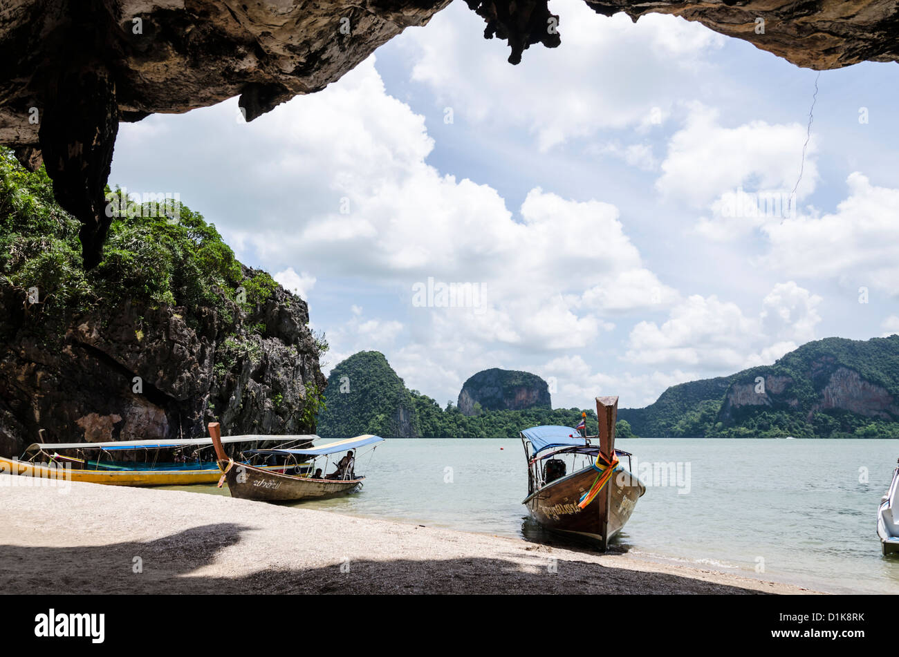 Longtail boats at beach on James Bond Island with rock overhang in Ao ...