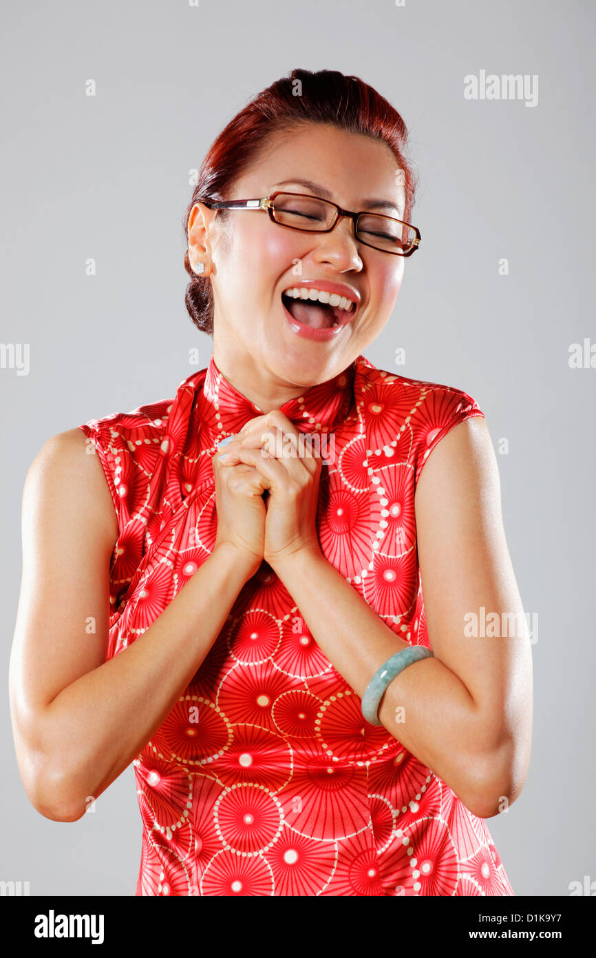 Woman clasping hands to chest and smiling Stock Photo - Alamy