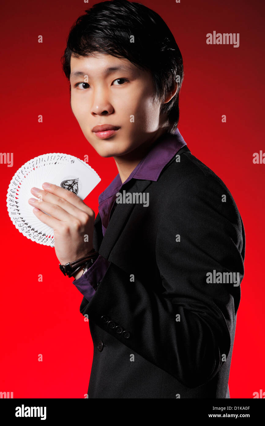 Man wearing a suit holding a deck of cards Stock Photo - Alamy