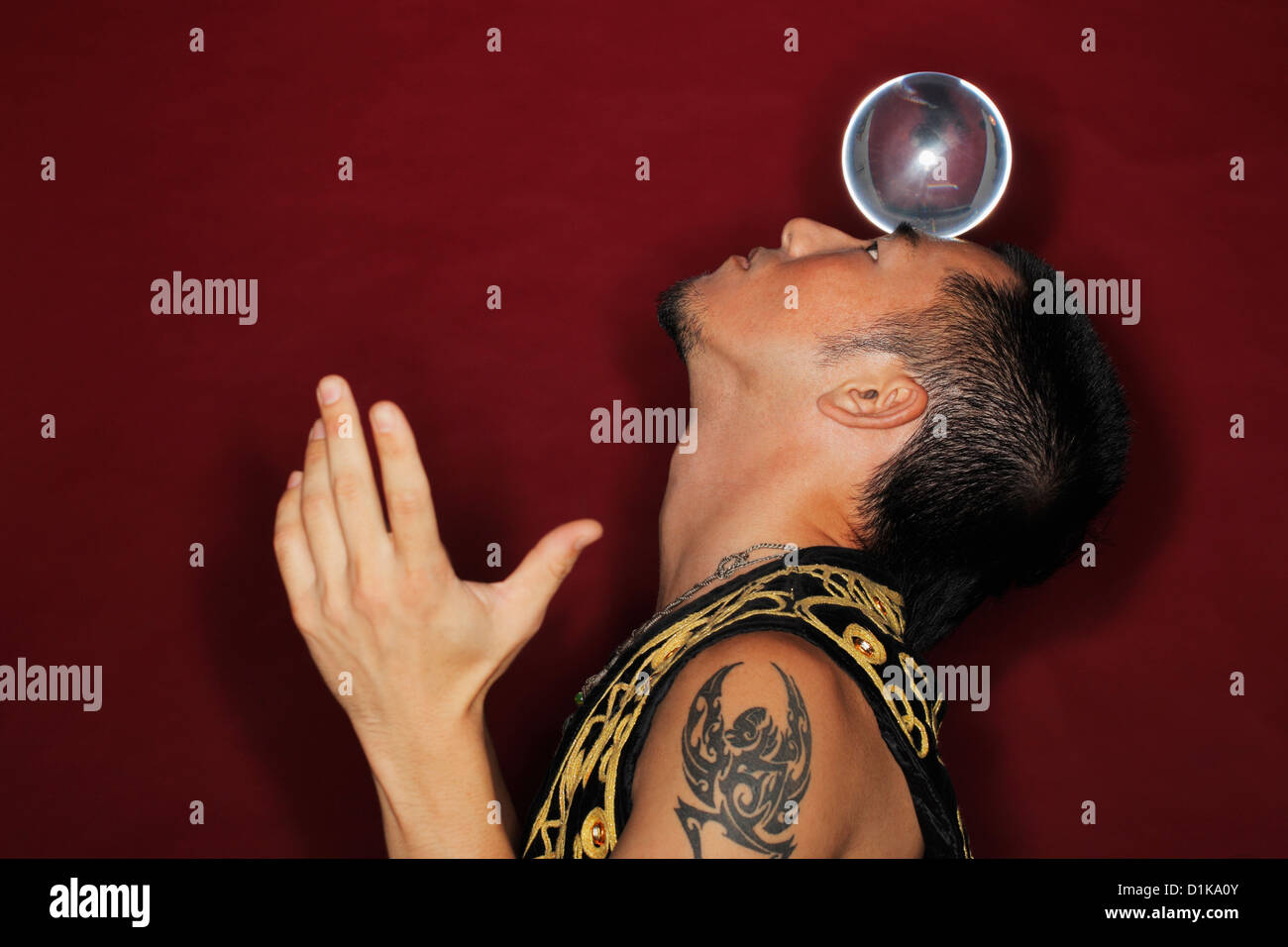 Man balancing crystal ball on his head Stock Photo - Alamy