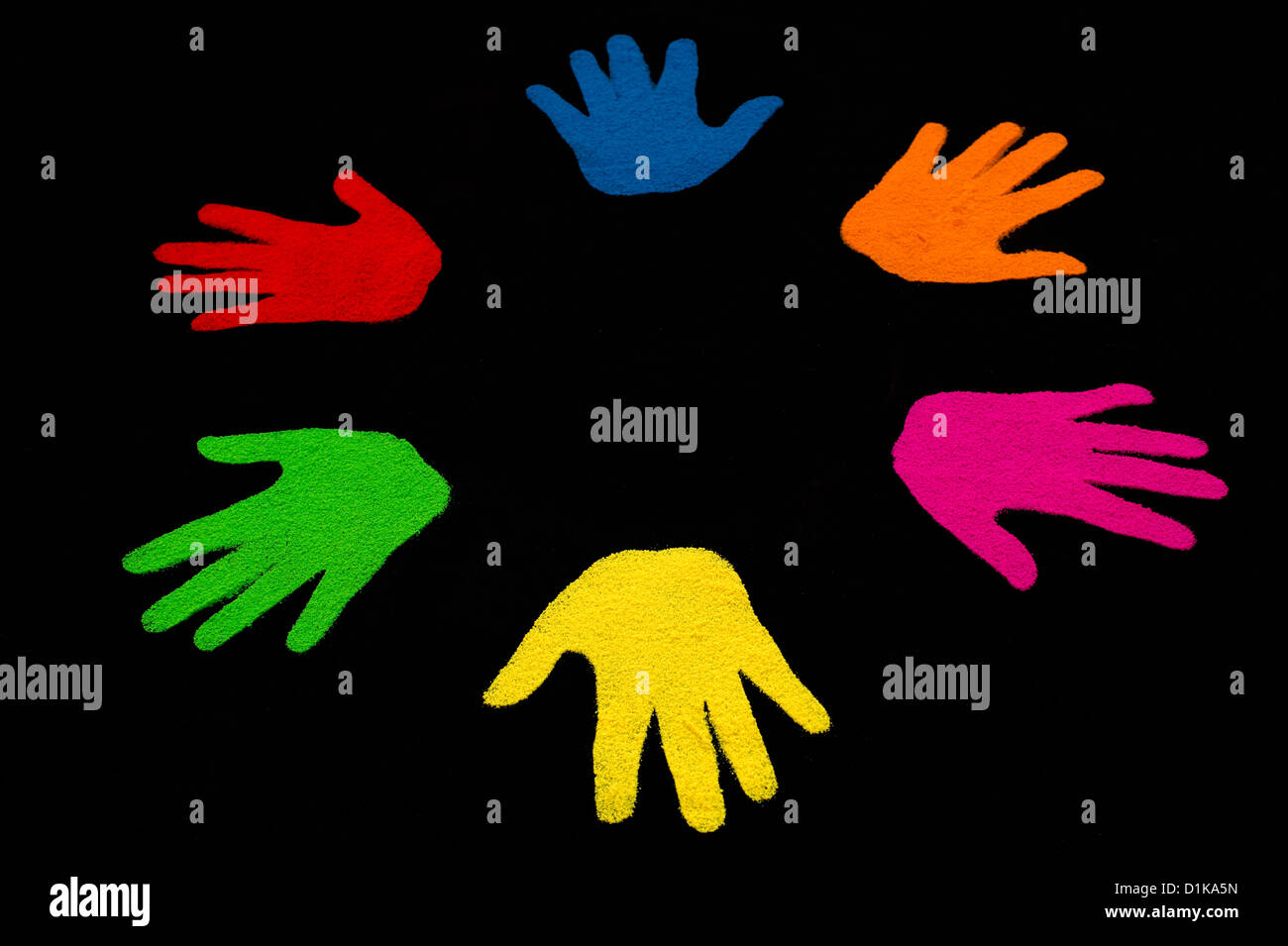 Coloured powder hand prints in a circular pattern on black Stock Photo ...
