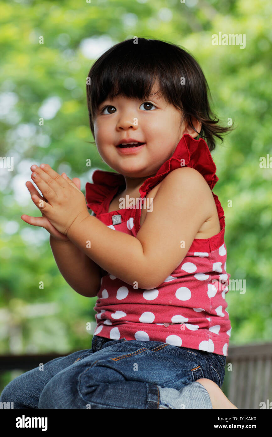 Young girl clapping her hands and smiling Stock Photo - Alamy