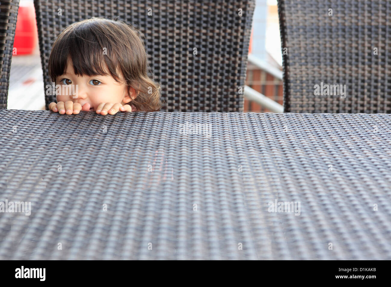 Young girl peering over a table Stock Photo - Alamy