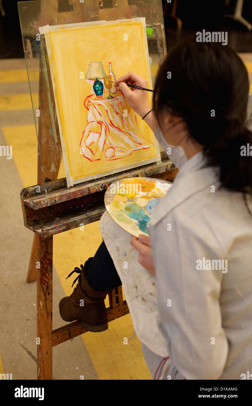 Rear view of young woman painting on an easel Stock Photo - Alamy