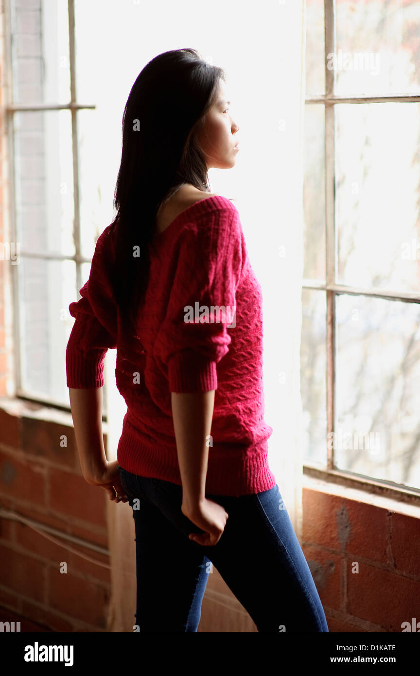 Profile of young woman looking out the window Stock Photo - Alamy