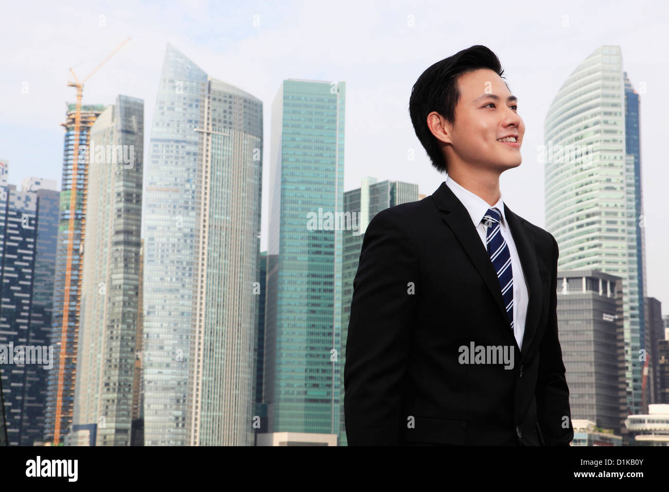Young man standing in front of buildings looking up Stock Photo - Alamy