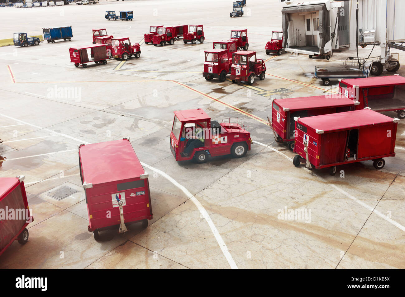 Red luggage containers on the tarmac of an airport Stock Photo - Alamy