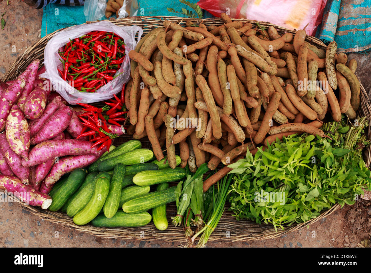 A woven basket of different vegetables sold in a market, Siem Reap ...