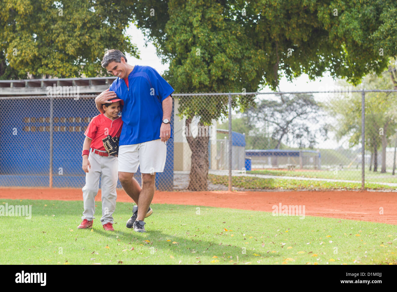 Hispanic coach and young baseball player Stock Photo - Alamy