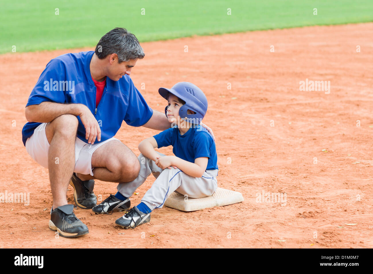 Hispanic coach and young baseball player Stock Photo - Alamy