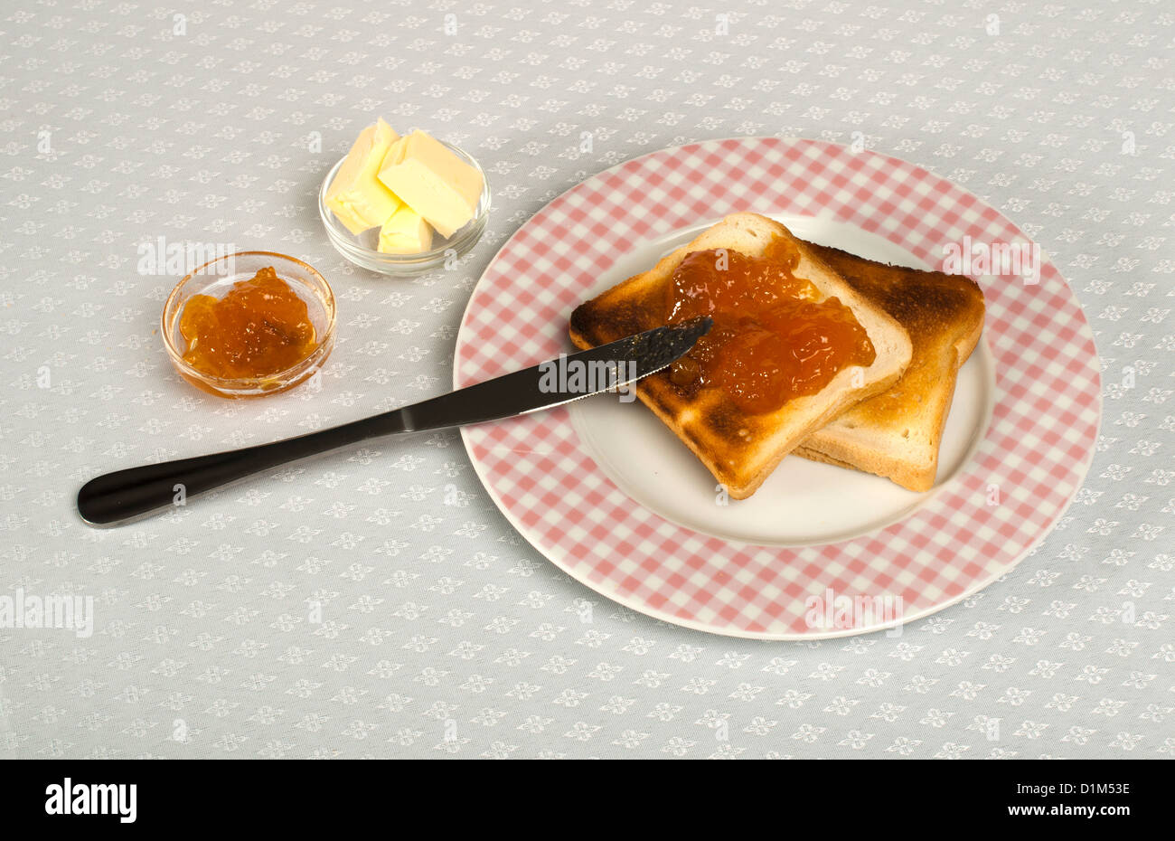 Spread jam on bread with knife Stock Photo - Alamy