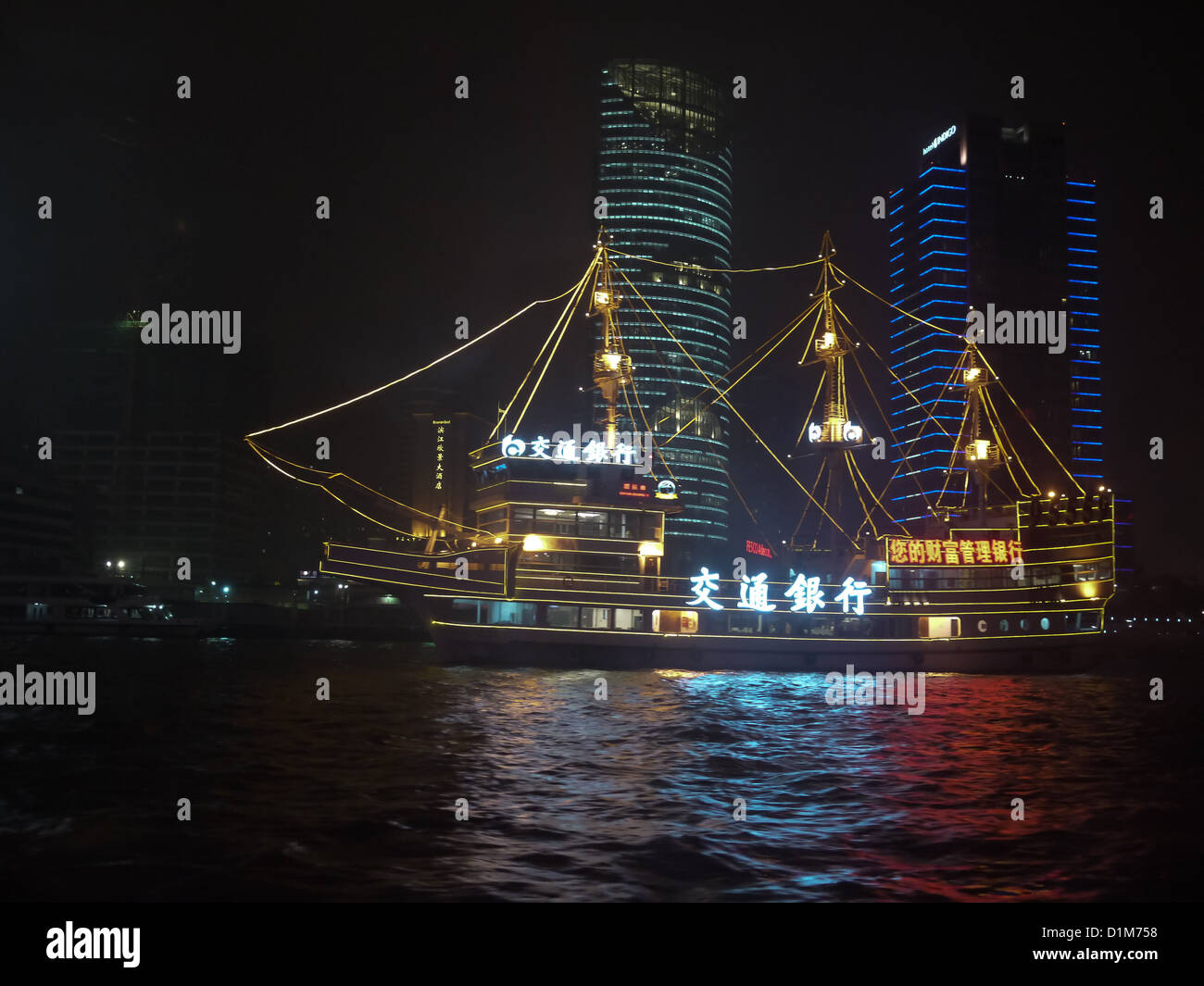 junk boat neon light night tall buildings Stock Photo - Alamy