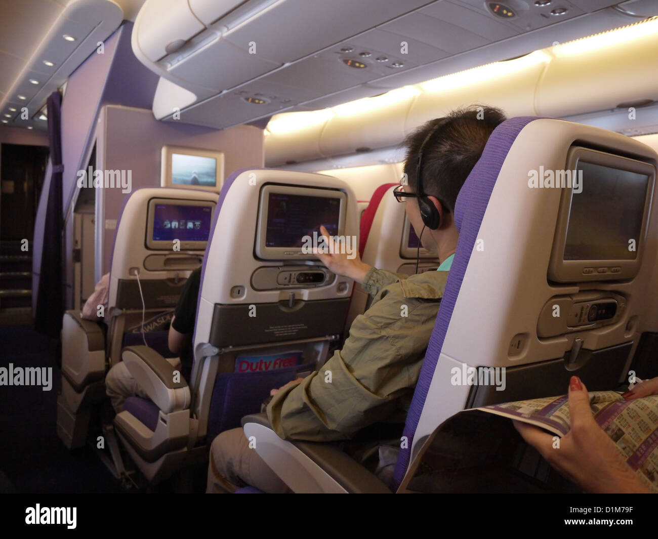 man listening audio in-flight airplane plane Stock Photo - Alamy