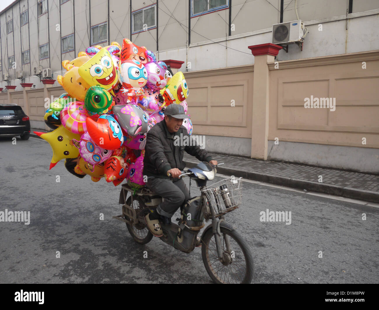 old chinese man riding bicycle with balloons Stock Photo - Alamy