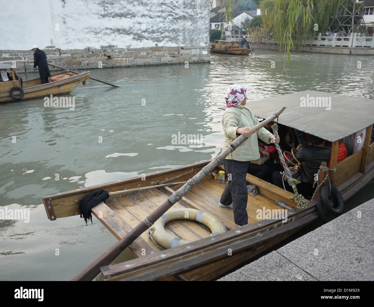 old chinese woman paddle padding wooden boat Stock Photo - Alamy