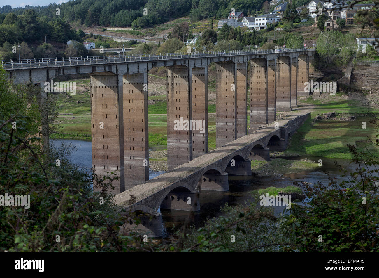 Ponte Nova de Portomarin towers over the old roman bridge spanning the ...