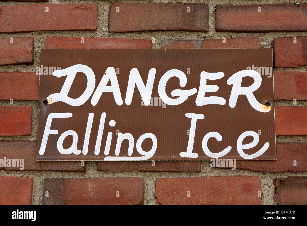 Sign on wall warning people of the danger of ice falling from the ...