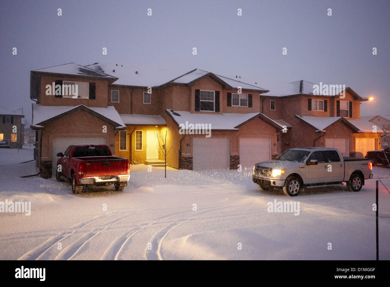 truck driving through street with snow falling in residential ...