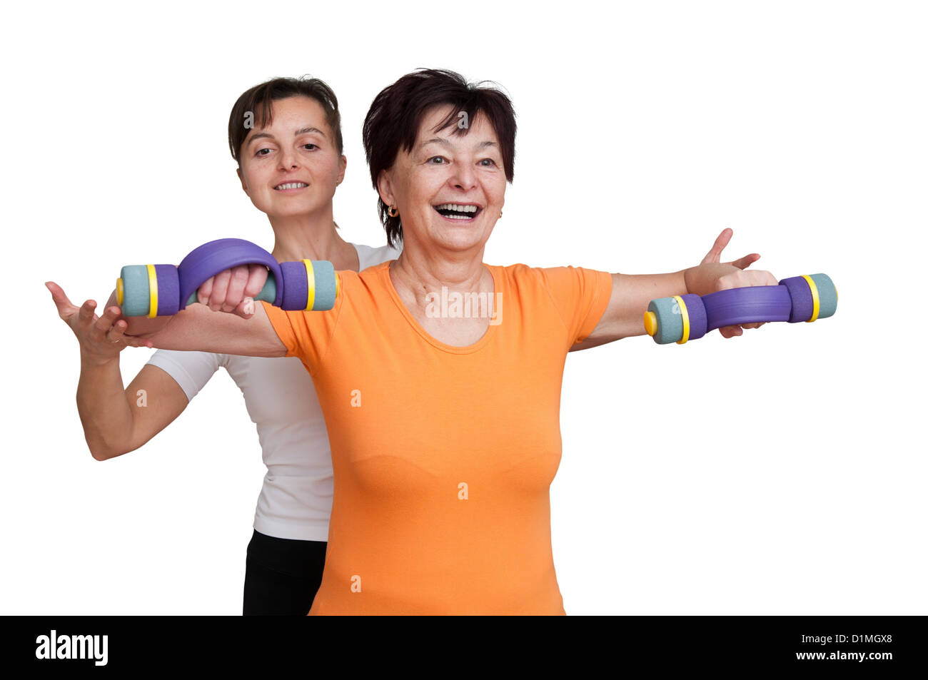 Smiling senior fitness woman exercising with barbells assisted by coach ...