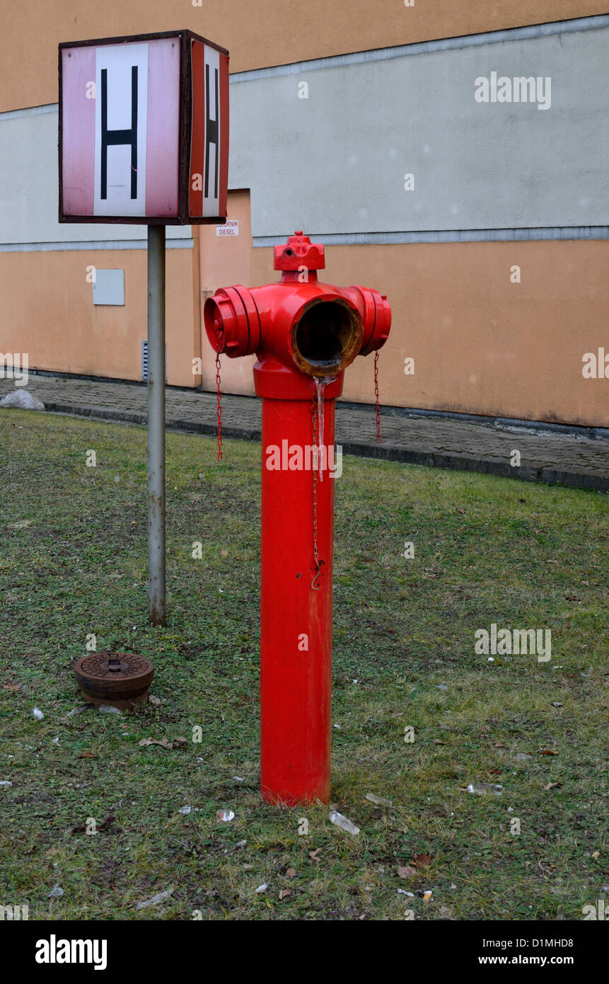 Red fire hydrant in front of wall Stock Photo - Alamy