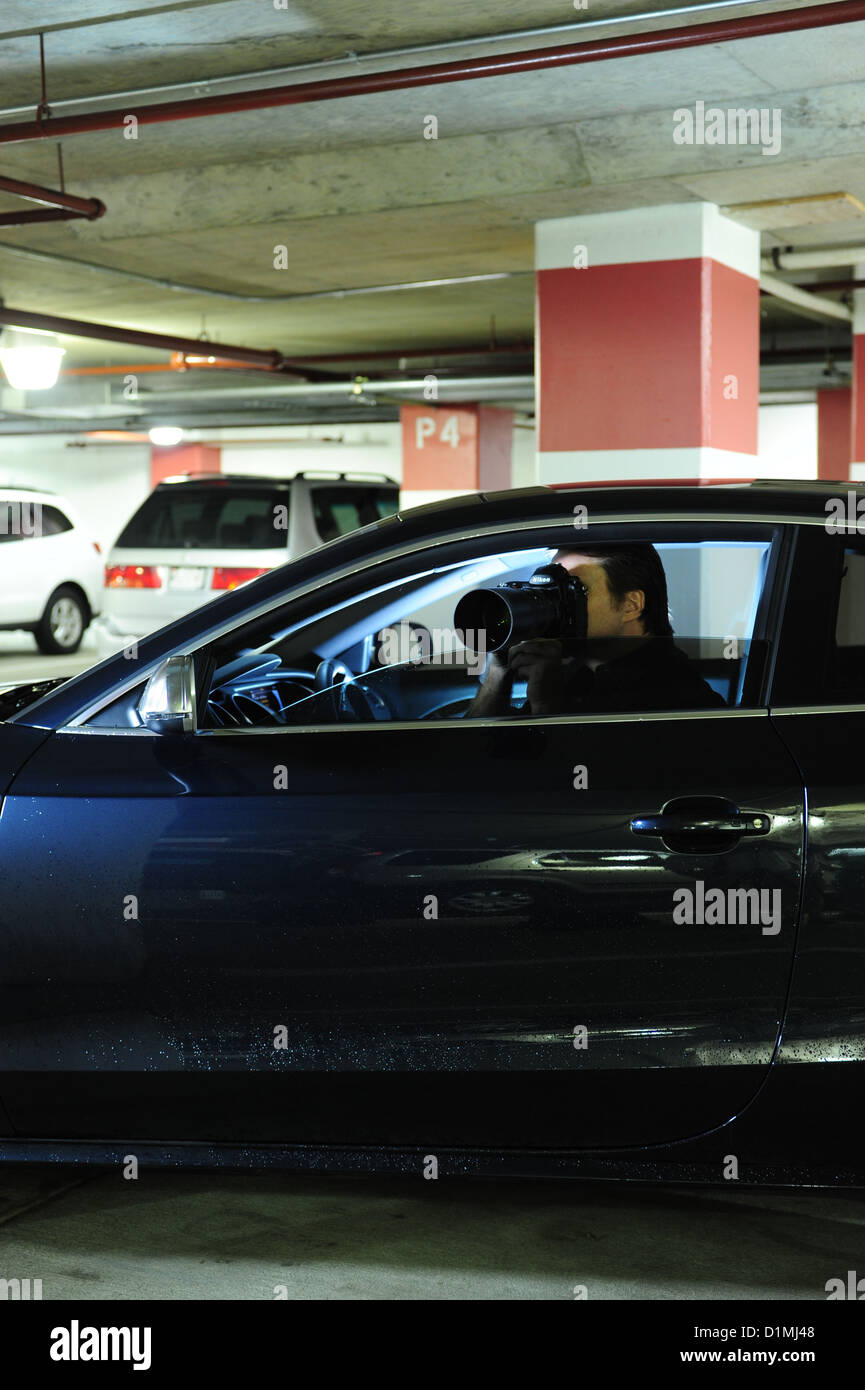 Private eye or private detective investigator in car with camera ...