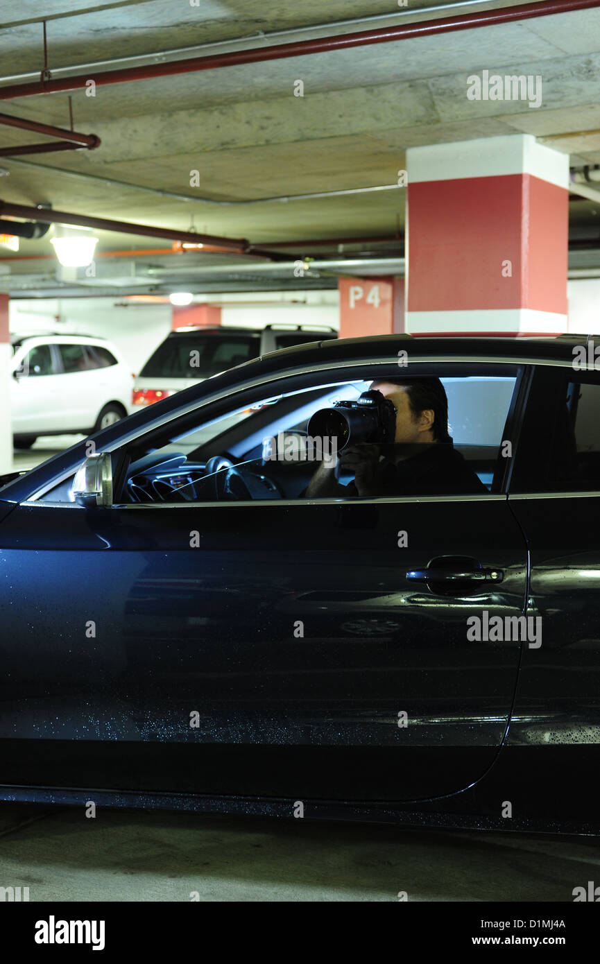 Private eye or private detective investigator in car with camera ...