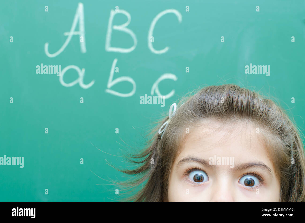 Scared Schoolgirl at Blackboard in classroom Stock Photo - Alamy