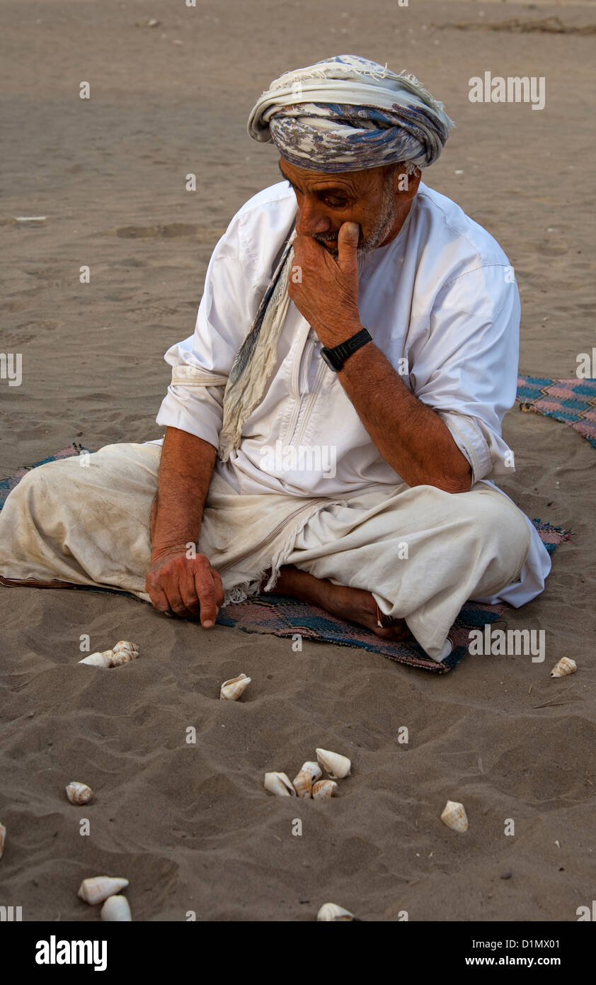 Omani man contemplating the next move in the Hawalis game, Sultanate of ...