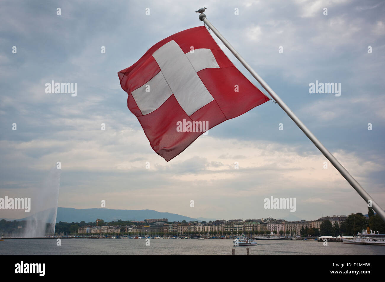 Swiss flag overlooking Lake Geneva with Jet d'Eau in the distance ...