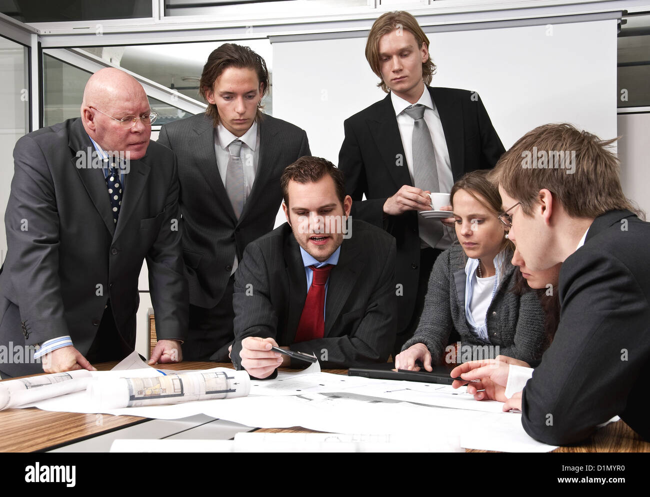 A company director and his staff, discussing plans, in a modern office ...
