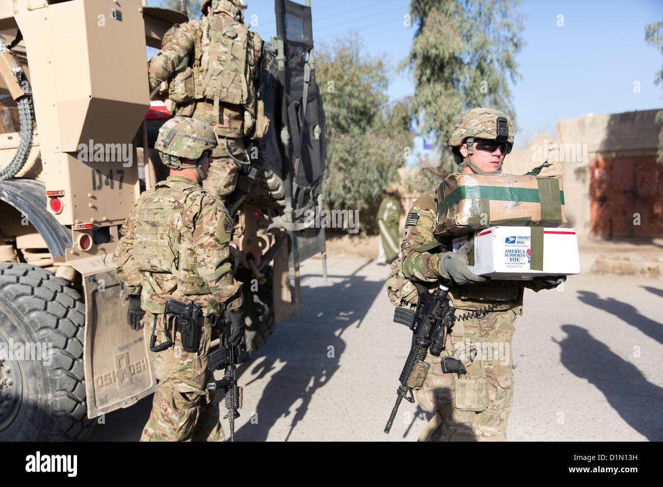 U.S. Army security force member carries school supplies to be delivered ...
