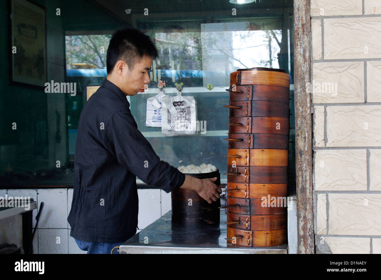 a chinese man making traditional chinese food dim sum (dumplings) in ...