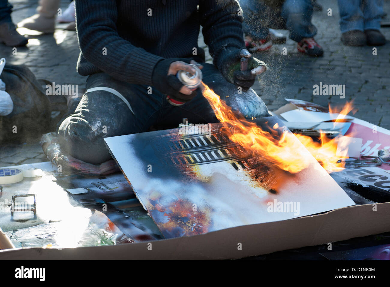 Street Artist paint and burn picture Stock Photo - Alamy