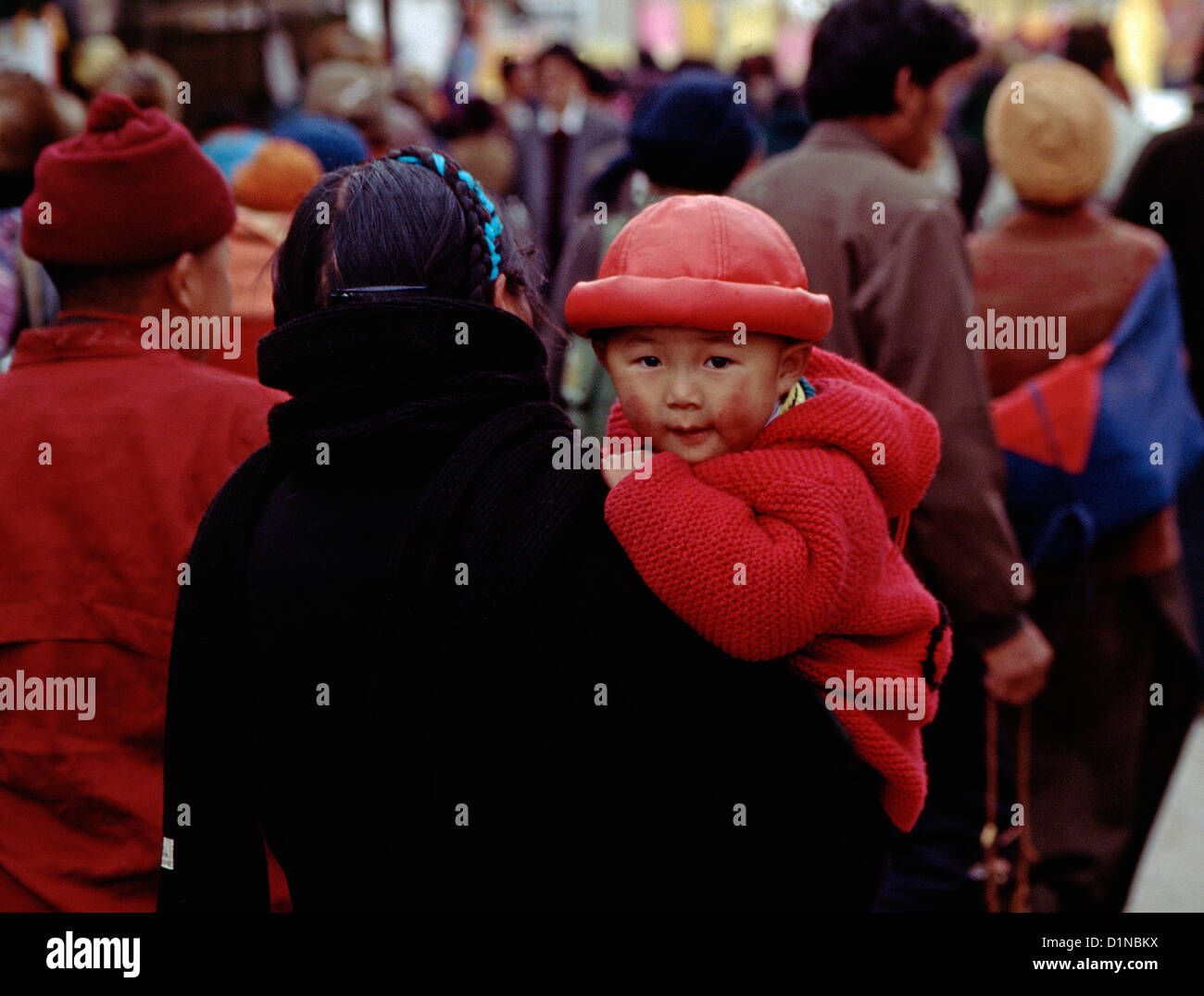 A young child looking over mother's shoulder, Lhasa, Tibet Stock Photo ...