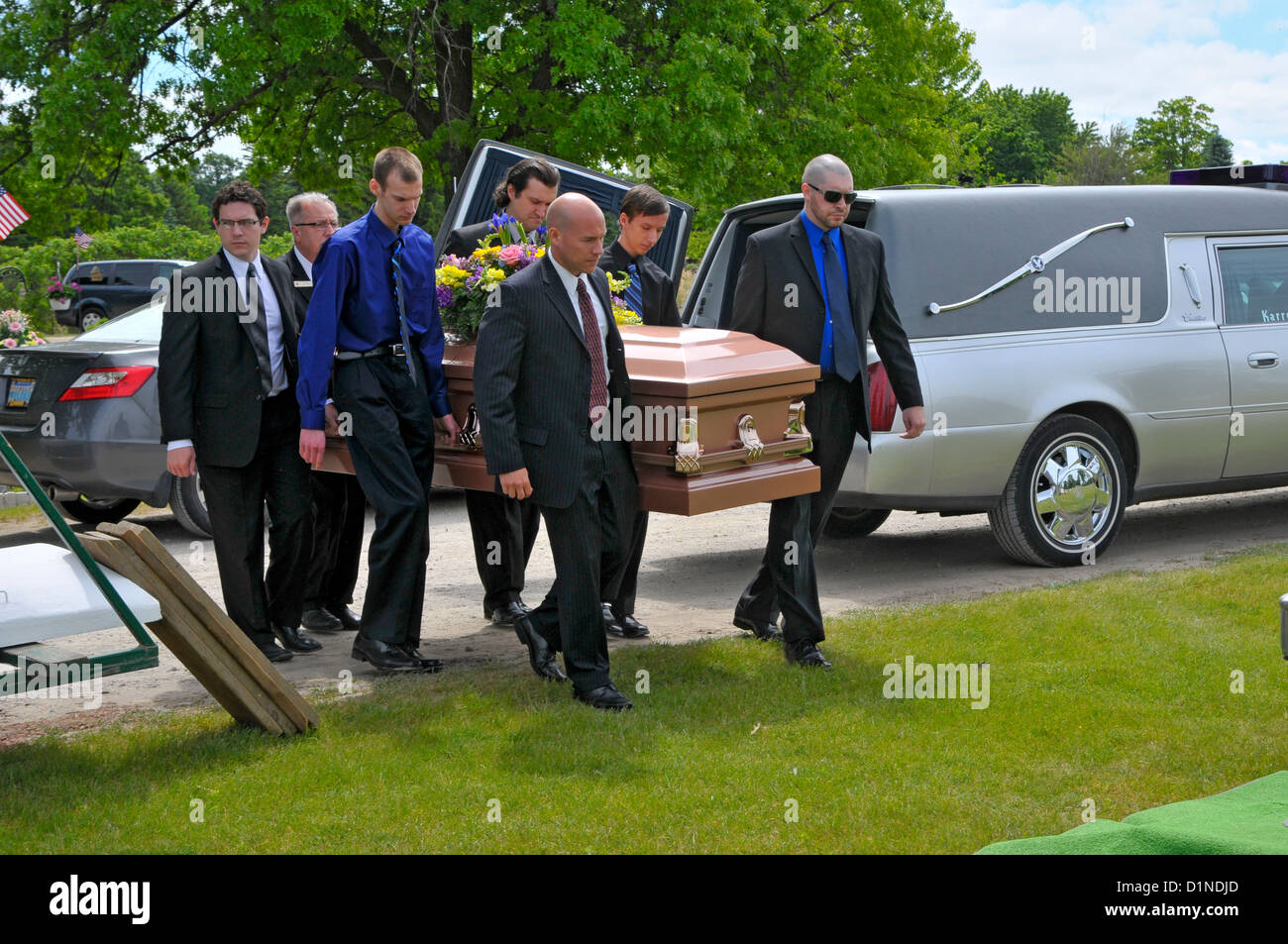 Funeral ending at cemetery gravesite with mourners and pallbearers ...