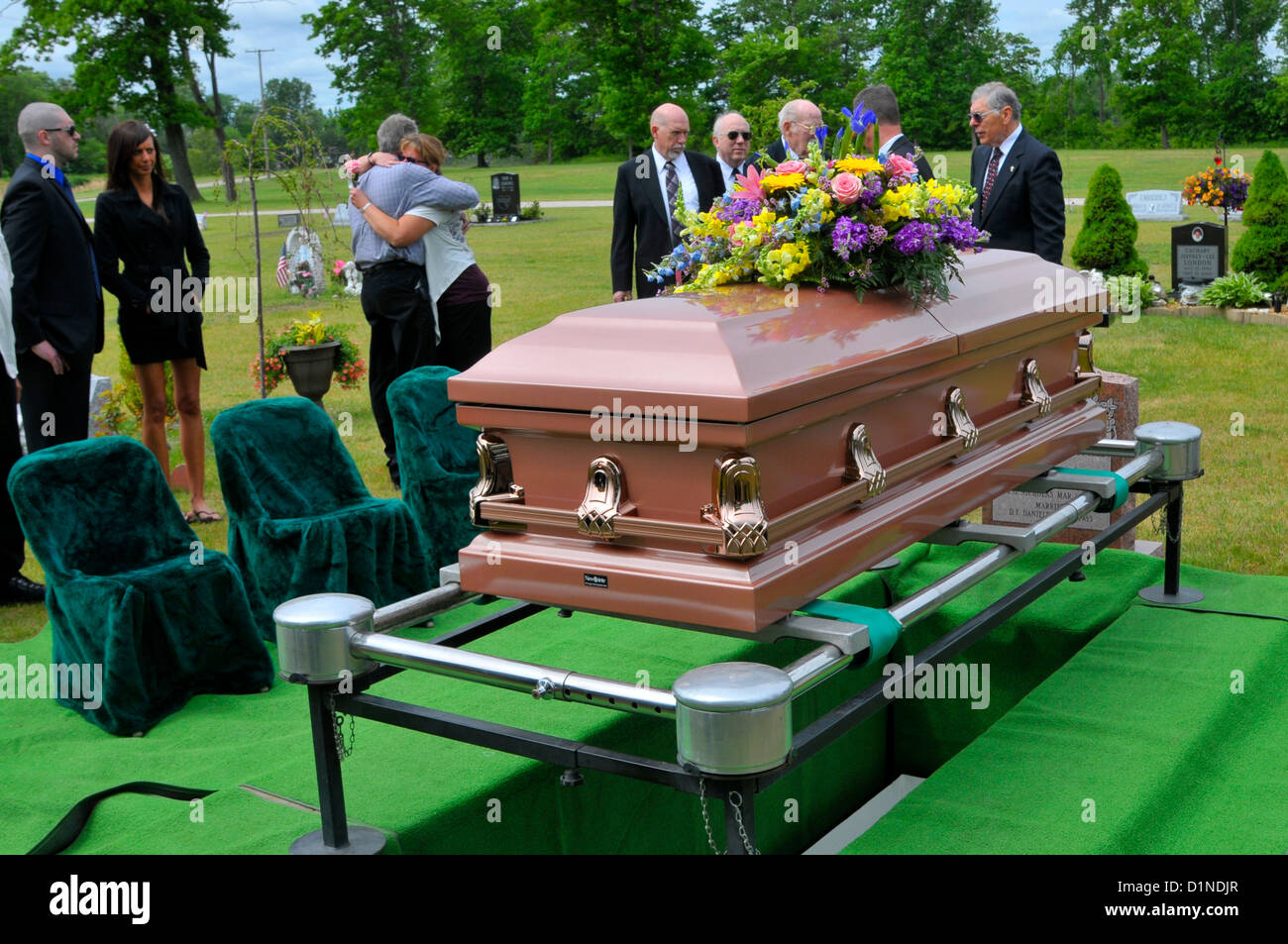 Funeral ending at cemetery gravesite with mourners and pallbearers ...