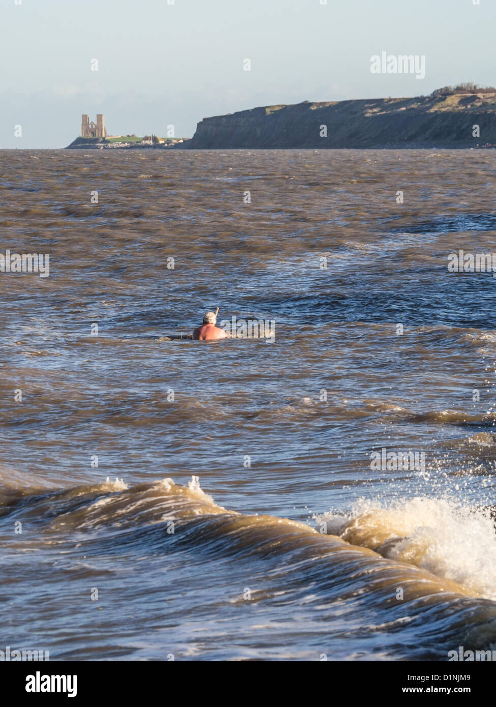 Kent, UK - January 1st 2013: A swimmer braves the chilly sea water on a ...