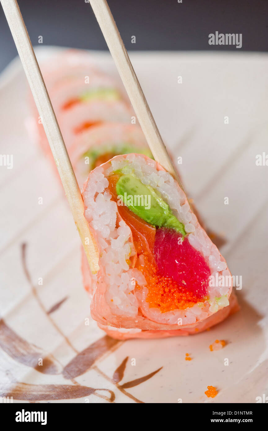 A sushi roll with pink rice paper, tuna, salmon and avocado Stock Photo ...