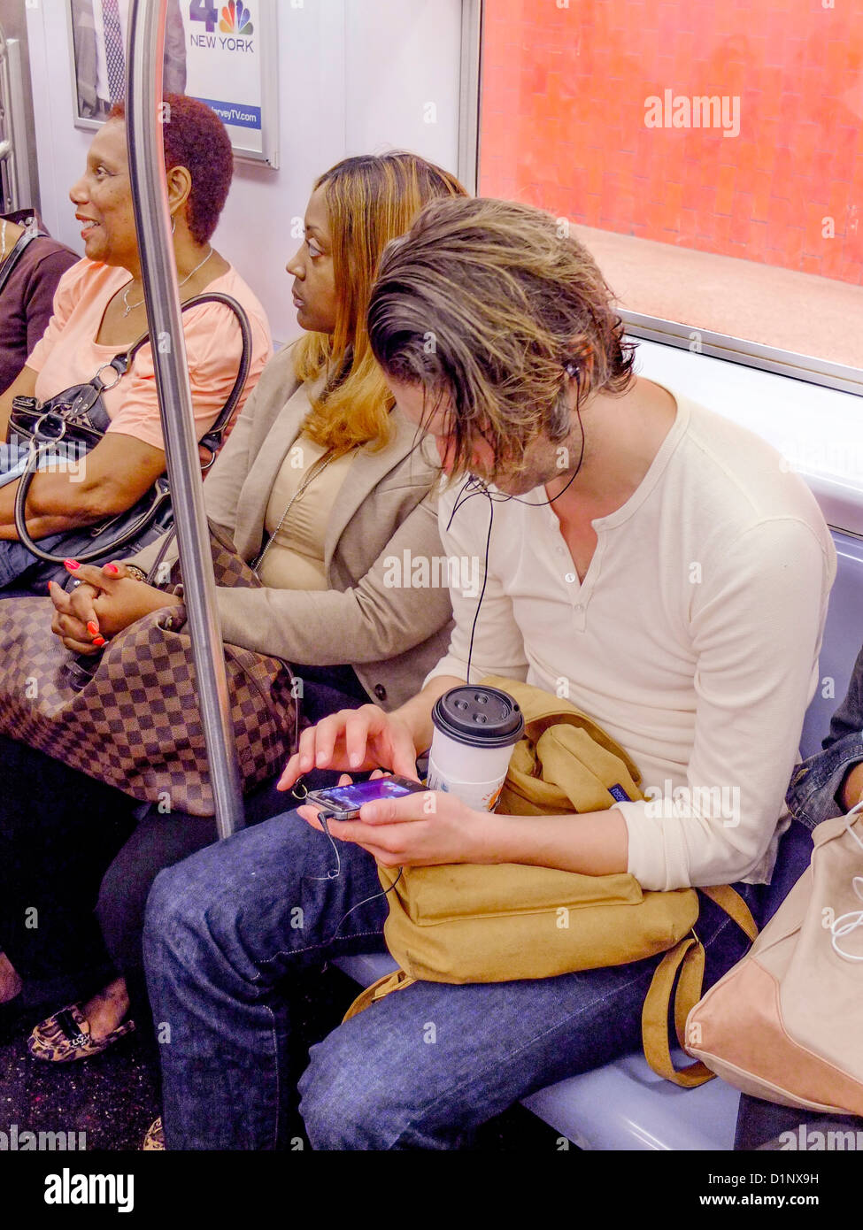 Surrounded by passengers, a young man plays a computer game on his ...