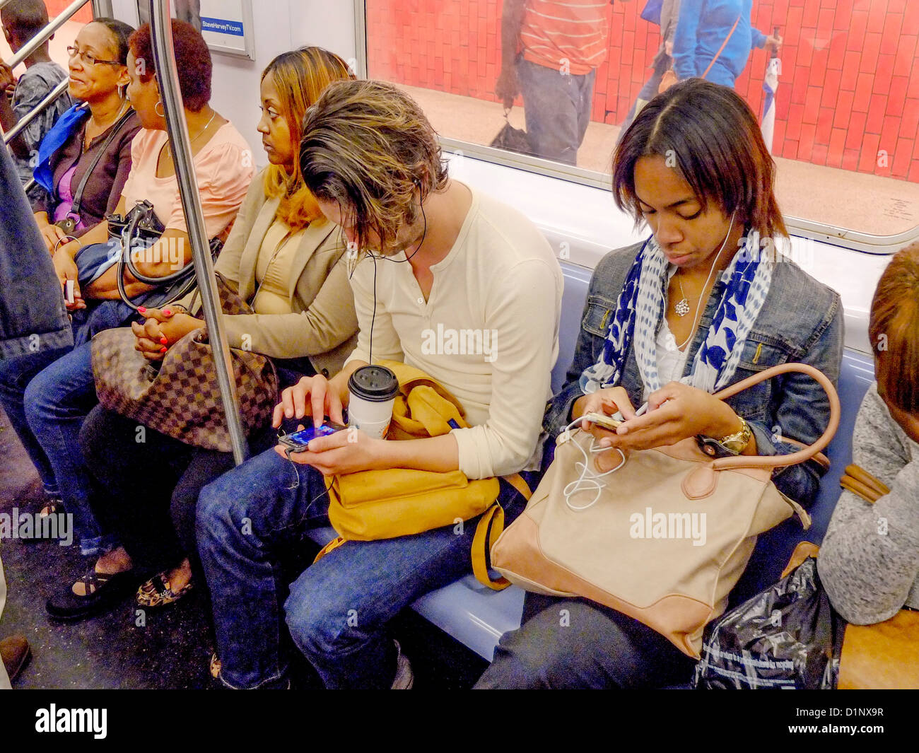 Surrounded by passengers, a young man plays a computer game on his ...