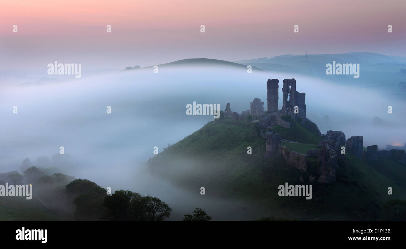 The ruins of Corfe Castle in Dorset rise out of the mist Stock Photo ...