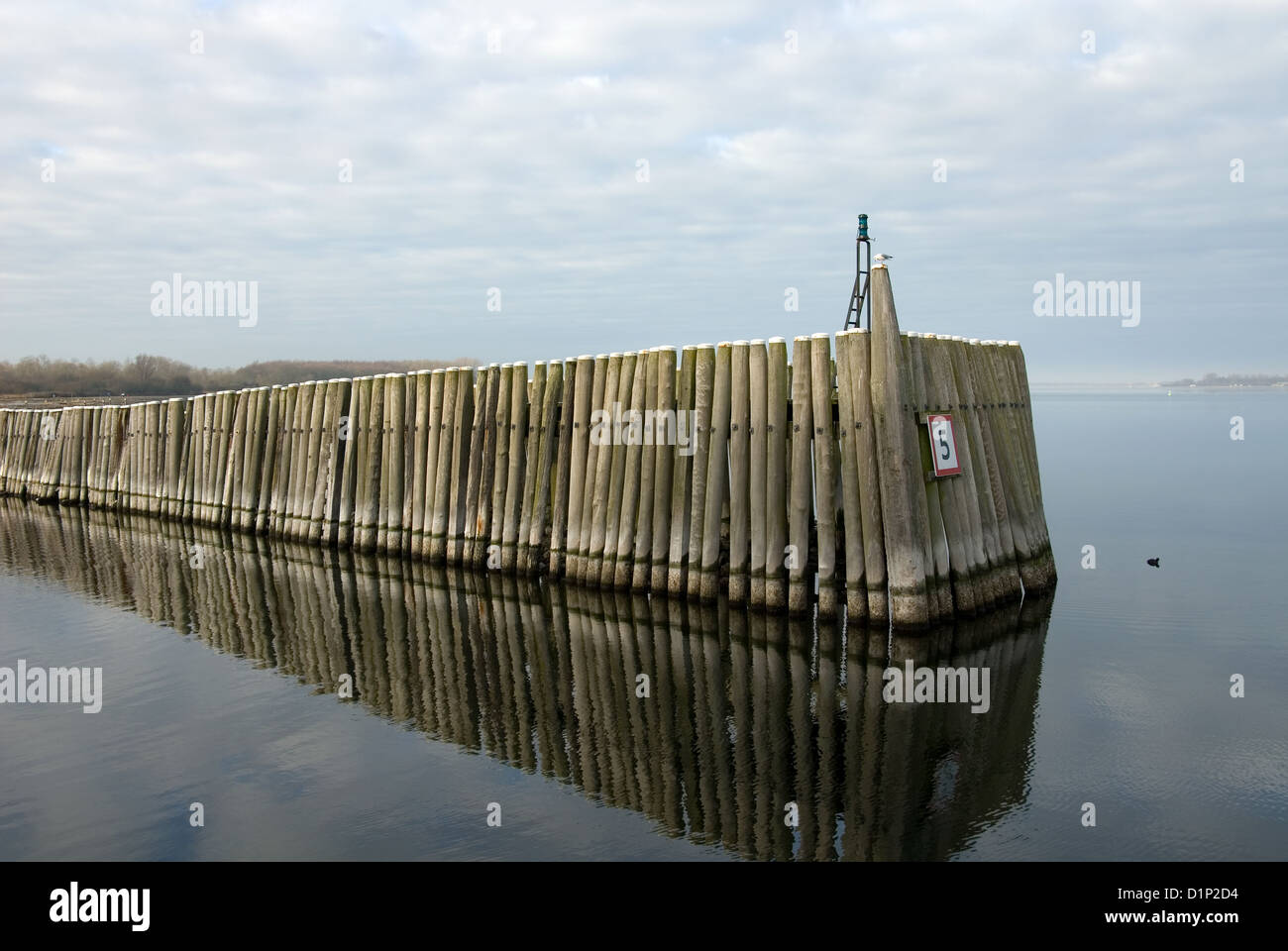 A wooden breakwater at the entrance to a small harbour, the Netherlands ...