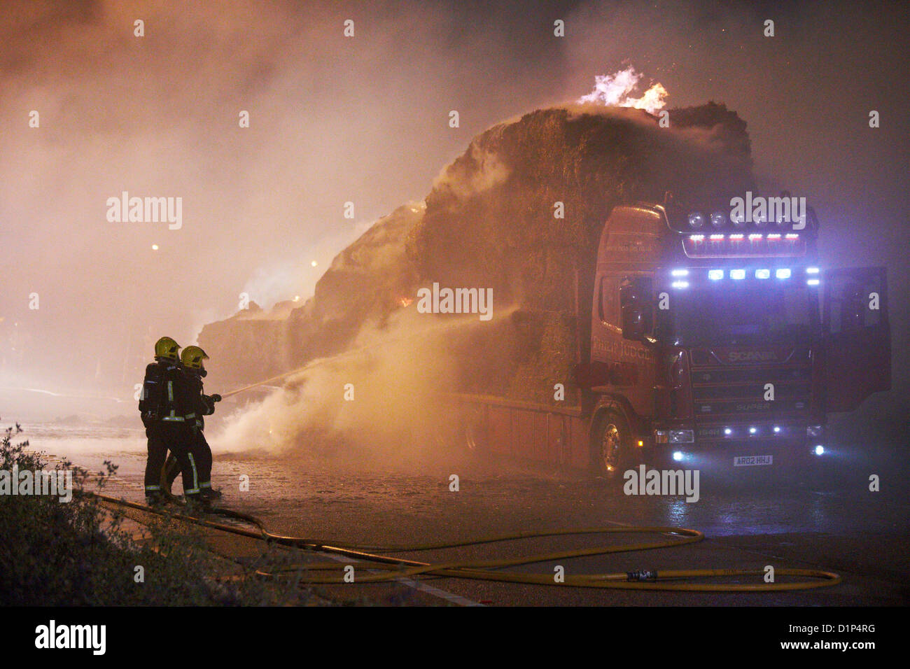 Fire fighters deal with a large hay lorry fire on the A41 near Aston ...