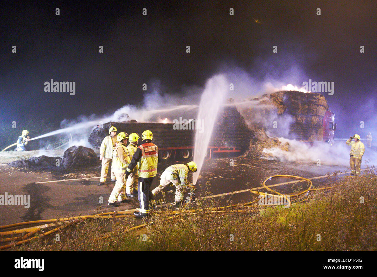 Fire fighters deal with a large hay lorry fire on the A41 near Aston ...