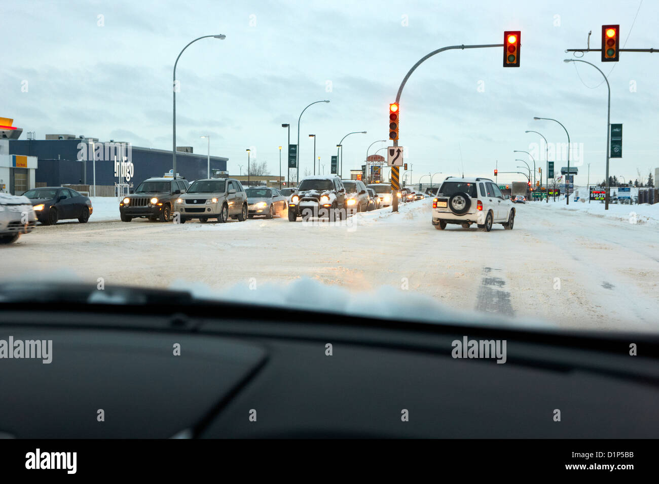 looking through car windshield at snow covered city intersection ...