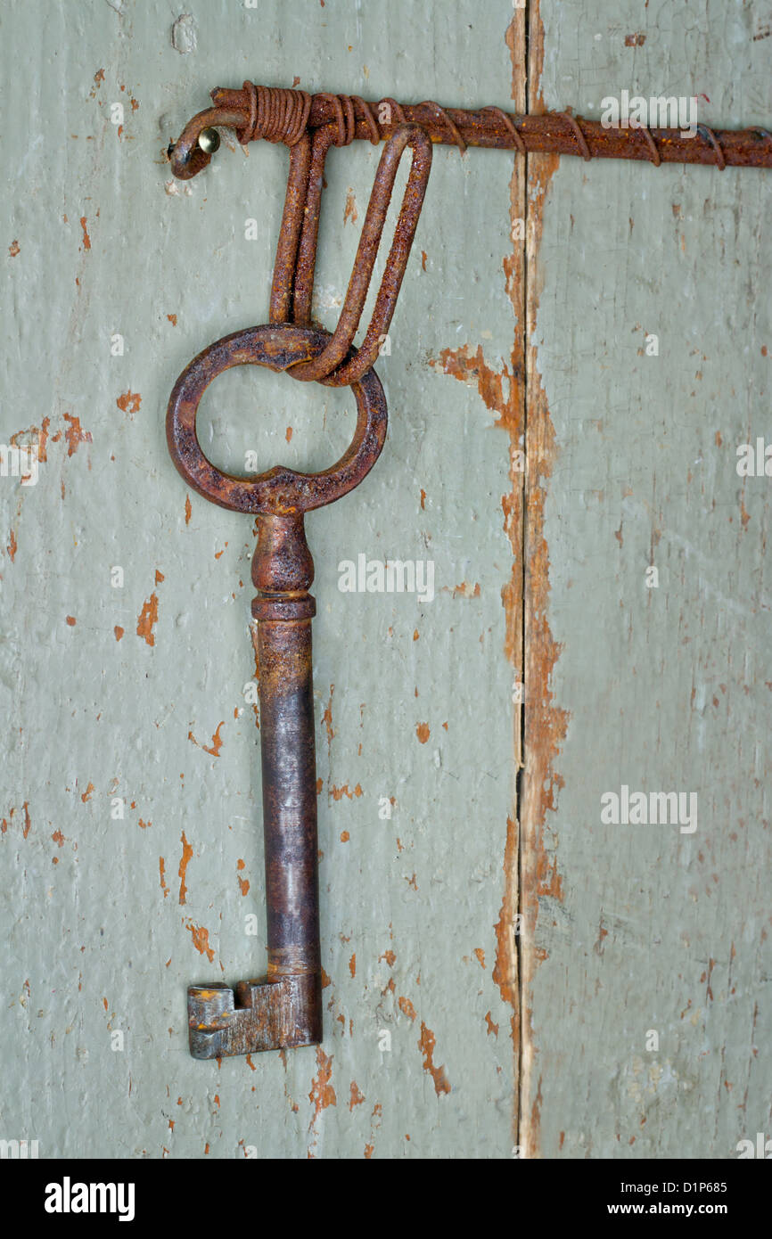 Antique key hanging on wooden rustic green background Stock Photo - Alamy