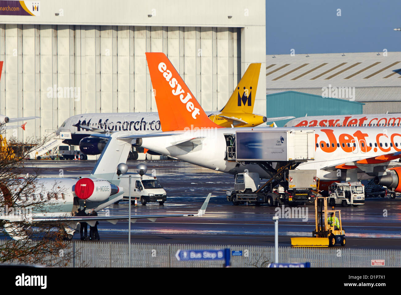 A snow plough (bottom right) clears a taxiway at Luton Airport ...