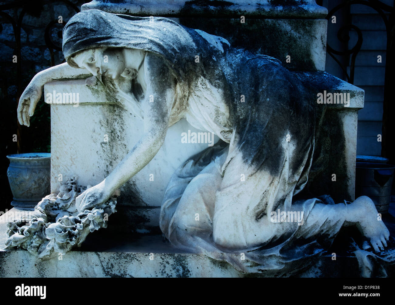 A sculpture in a cemetery in Nice France depicting a sad grieving woman ...