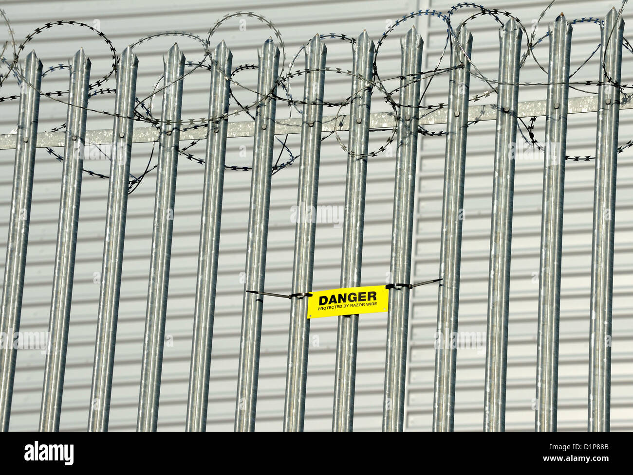 Danger sign warning of concertina razor wire mounted onto galvanized ...